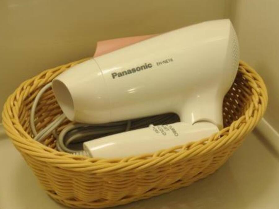 Um secador de cabelo Panasonic numa cesta de vime.