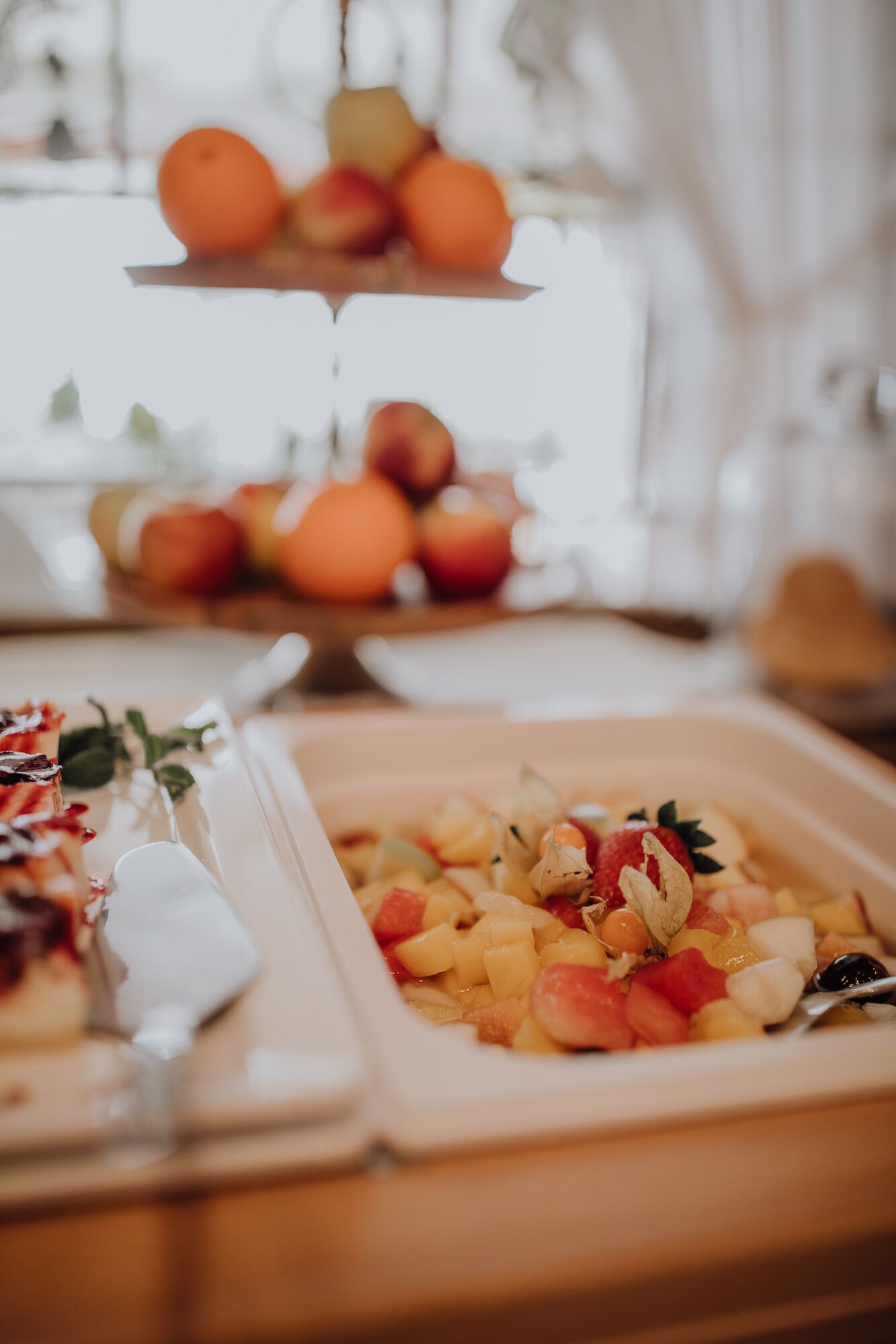 Uma mesa de buffet com diversas frutas e sobremesas.