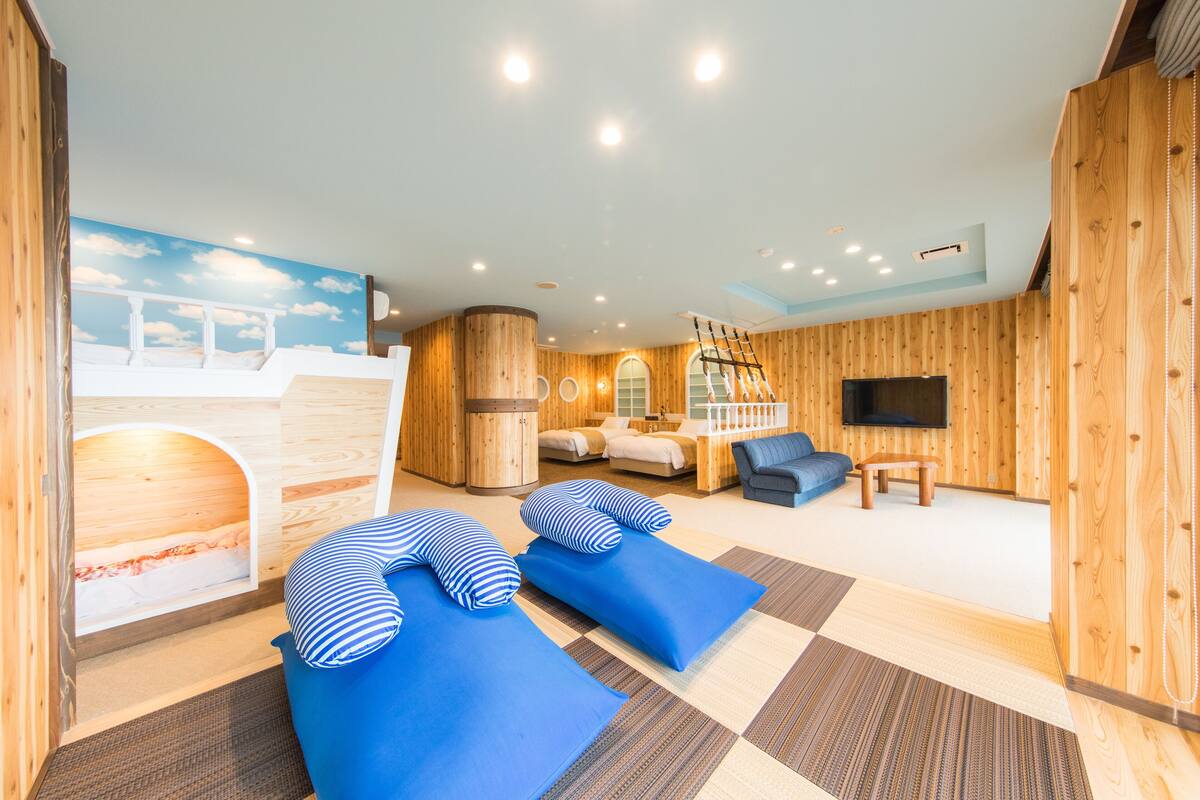 Um spa moderno com paredes de madeira, uma mesa de massagem, uma sauna e uma televisão.