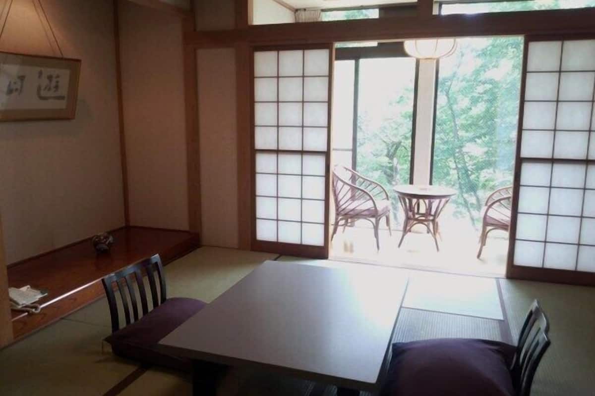 Um quarto japonês tradicional com tatames, uma mesa baixa e biombos shoji.