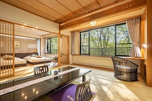 Um quarto em estilo japonês tradicional, com tatames, uma mesa baixa e uma porta deslizante.