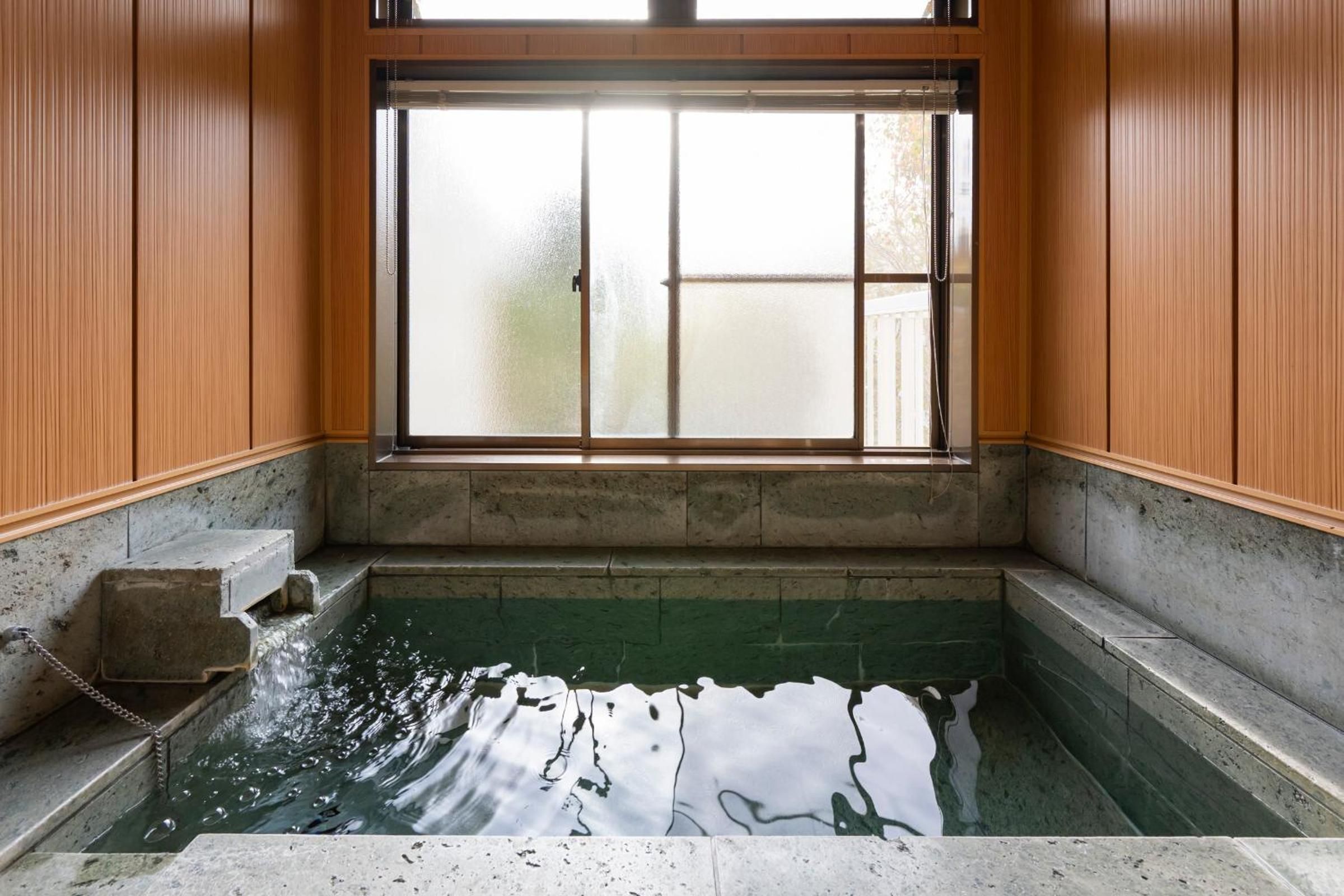 Quarto com uma janela grande, uma piscina pequena e lambris de madeira.