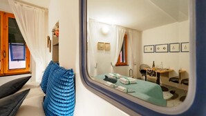 Quarto com cama, escrivaninha e janela com cortinas.