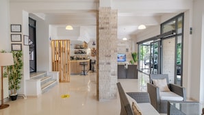 Um hall amplo com balcão de recepção, área de estar e bar.