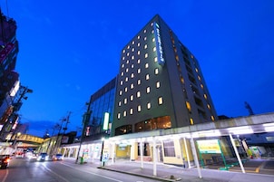 Um hotel moderno com vários andares e uma entrada imponente.