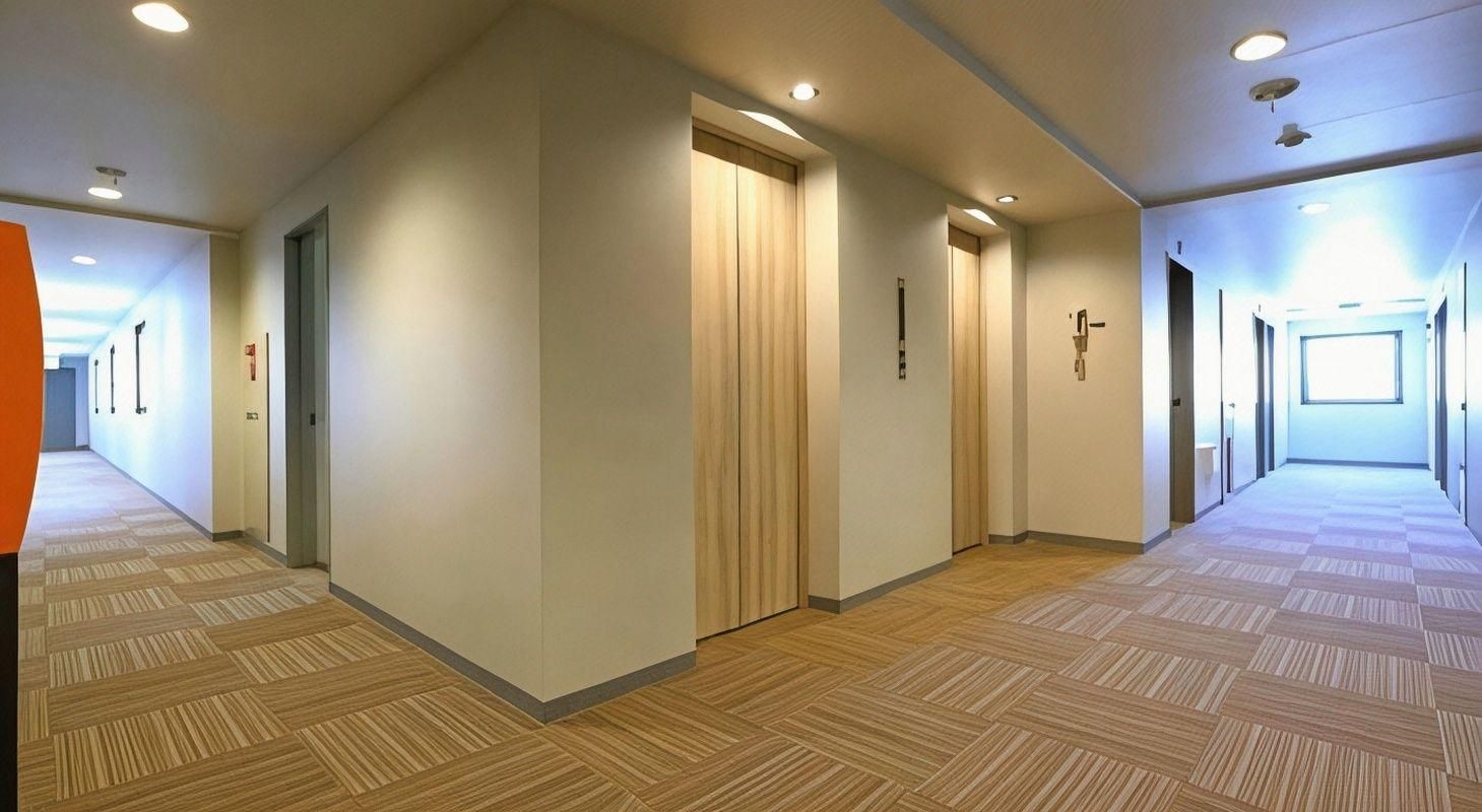 Corredor com piso coberto por carpete, portas de madeira e iluminação embutida.