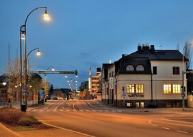 Vista da rua ao entardecer, com um edifício identificado como