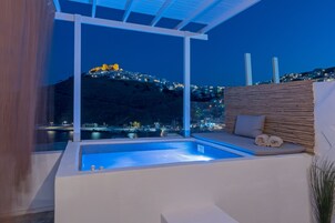 Uma área de piscina moderna ao ar livre, com vista para um horizonte urbano e uma colina ao fundo.