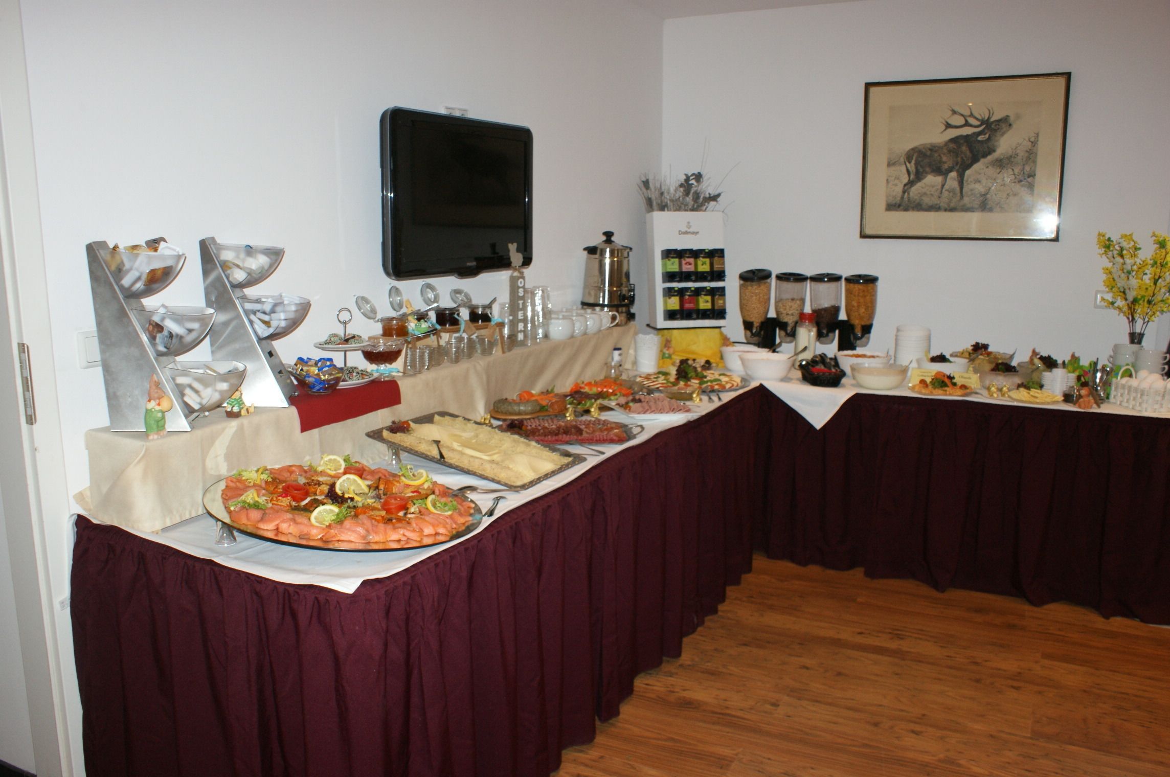 Mesa de buffet com diversos alimentos e um espaço para café.