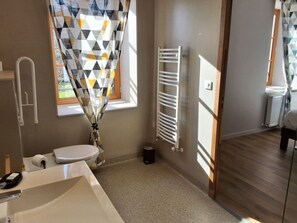 Uma casa de banho moderna com sanita, lavatório e zona de duche.