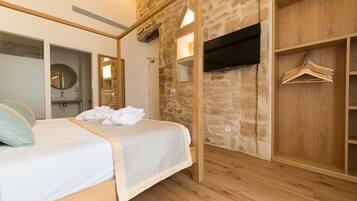 Quarto com cama, guarda-roupa de madeira e parede de pedra.