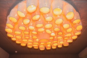Um lustre grande e circular com várias luminárias laranja e brancas.