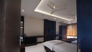 Um quarto moderno com uma cama grande, um ventilador de teto e uma mesa de cabeceira.