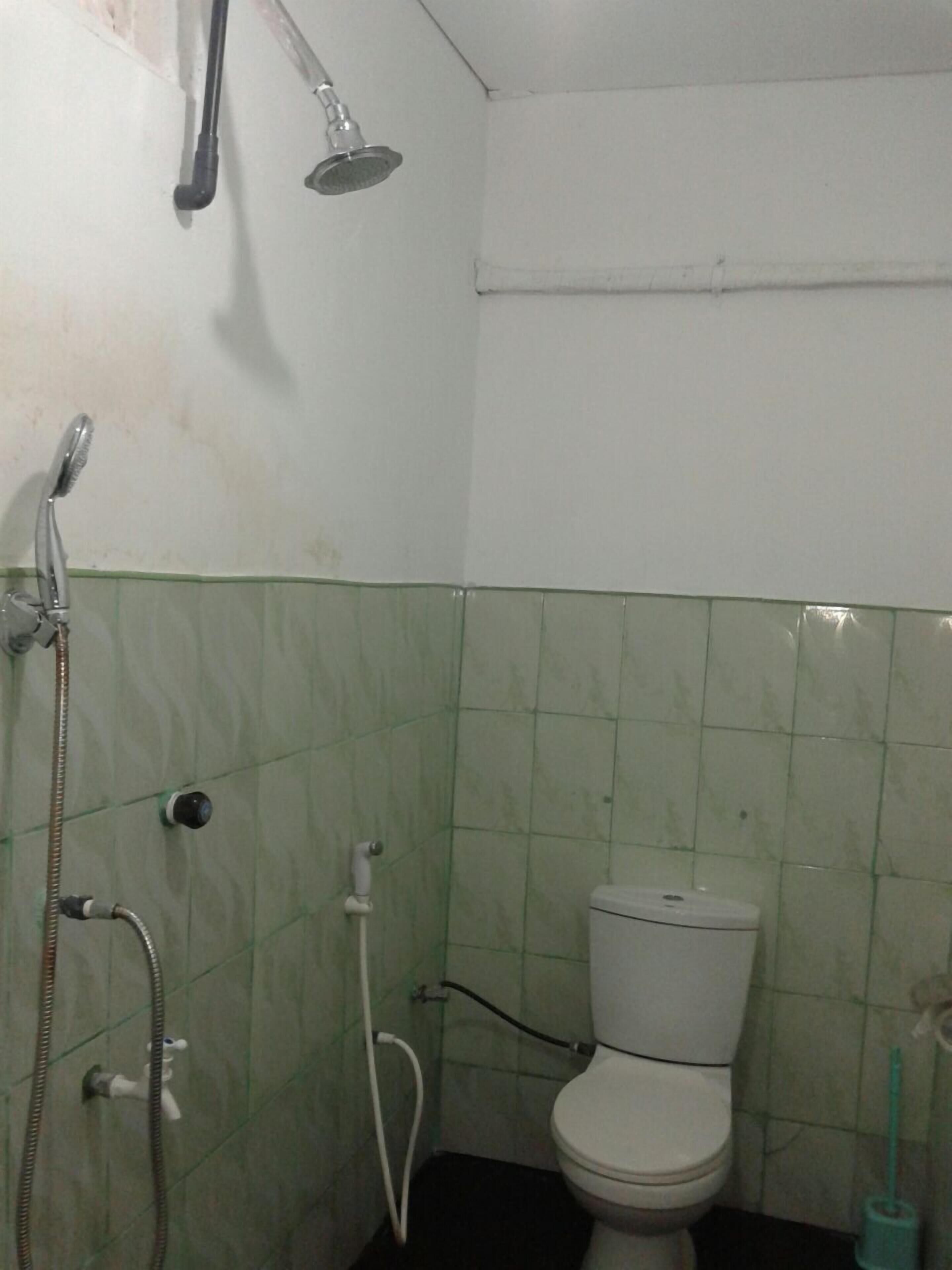 Casa de banho | Um polibã, um chuveiro fixo, artigos de higiene pessoal grátis 