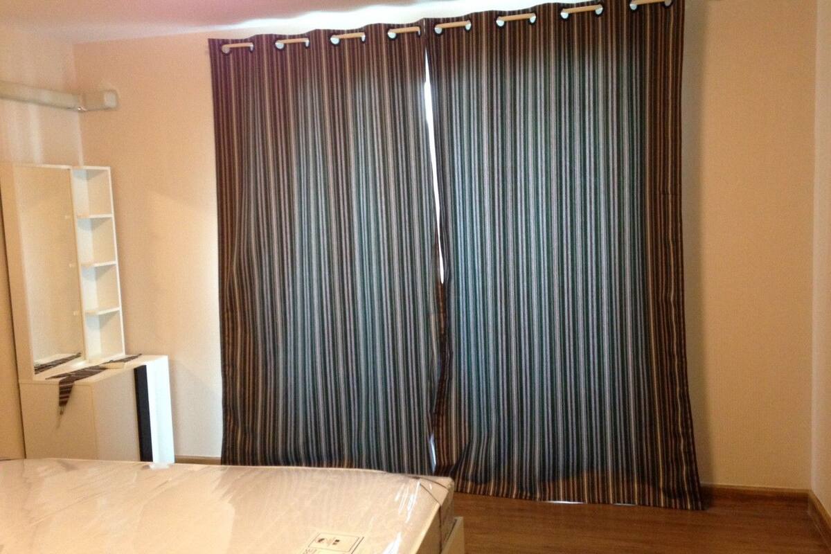 Um quarto com cama, guarda-roupa e espelho.