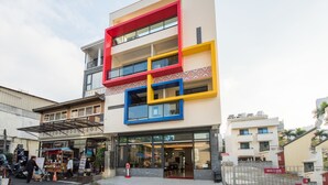 Edifício moderno com vários andares, combinando painéis de vidro e superfícies sólidas.