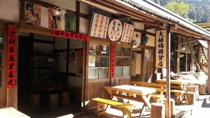 Uma pousada tradicional japonesa com mobiliário de madeira e sinalização em japonês.