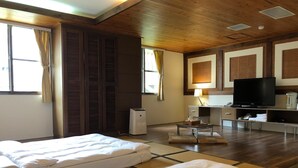 Quarto de hotel com duas camas, uma mesa com televisão, máquina de café e aquecedor.