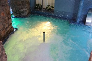 Piscina interior, uma piscina com cascata, espreguiçadeiras 