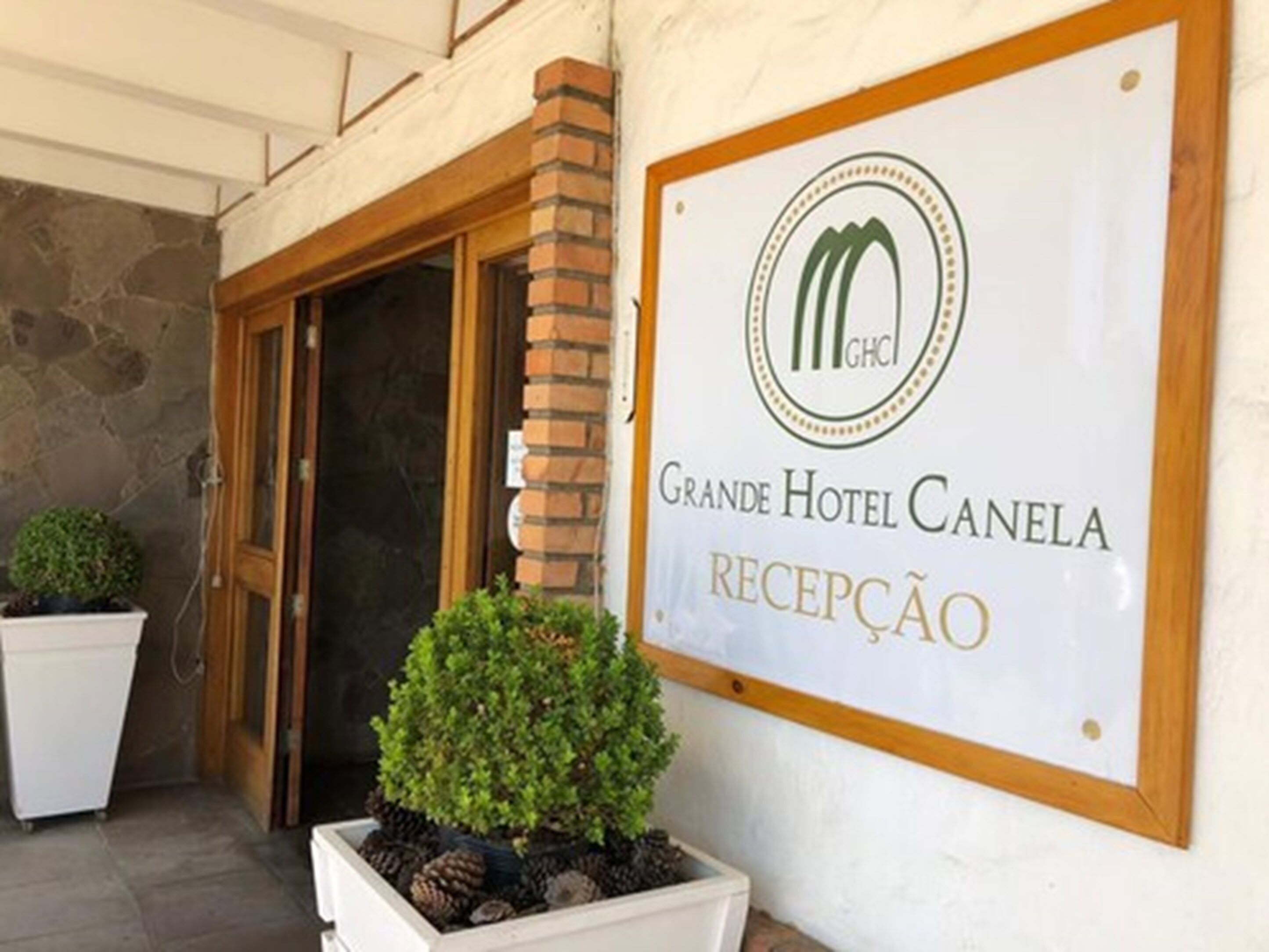 Entrada do Grande Hotel Canela, com uma placa de recepção.