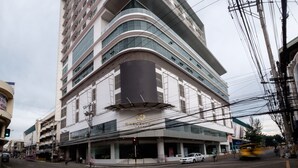 Um hotel de vários andares com design moderno, apresentando uma fachada curva e grandes janelas.