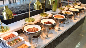 Buffet com diversos pratos e balcão com espelho.