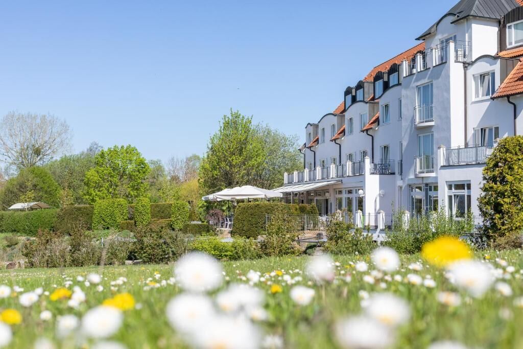 Hotel de vários andares com um jardim em primeiro plano.