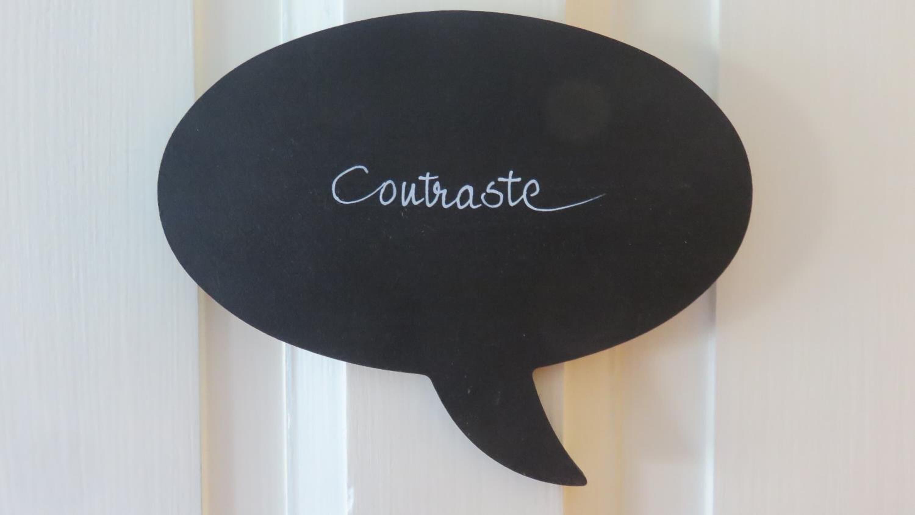 Uma balão de fala preta com a palavra 'Contrast' escrita em branco.