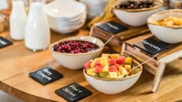 Um buffet de café da manhã com diversas opções de frutas e cereais.