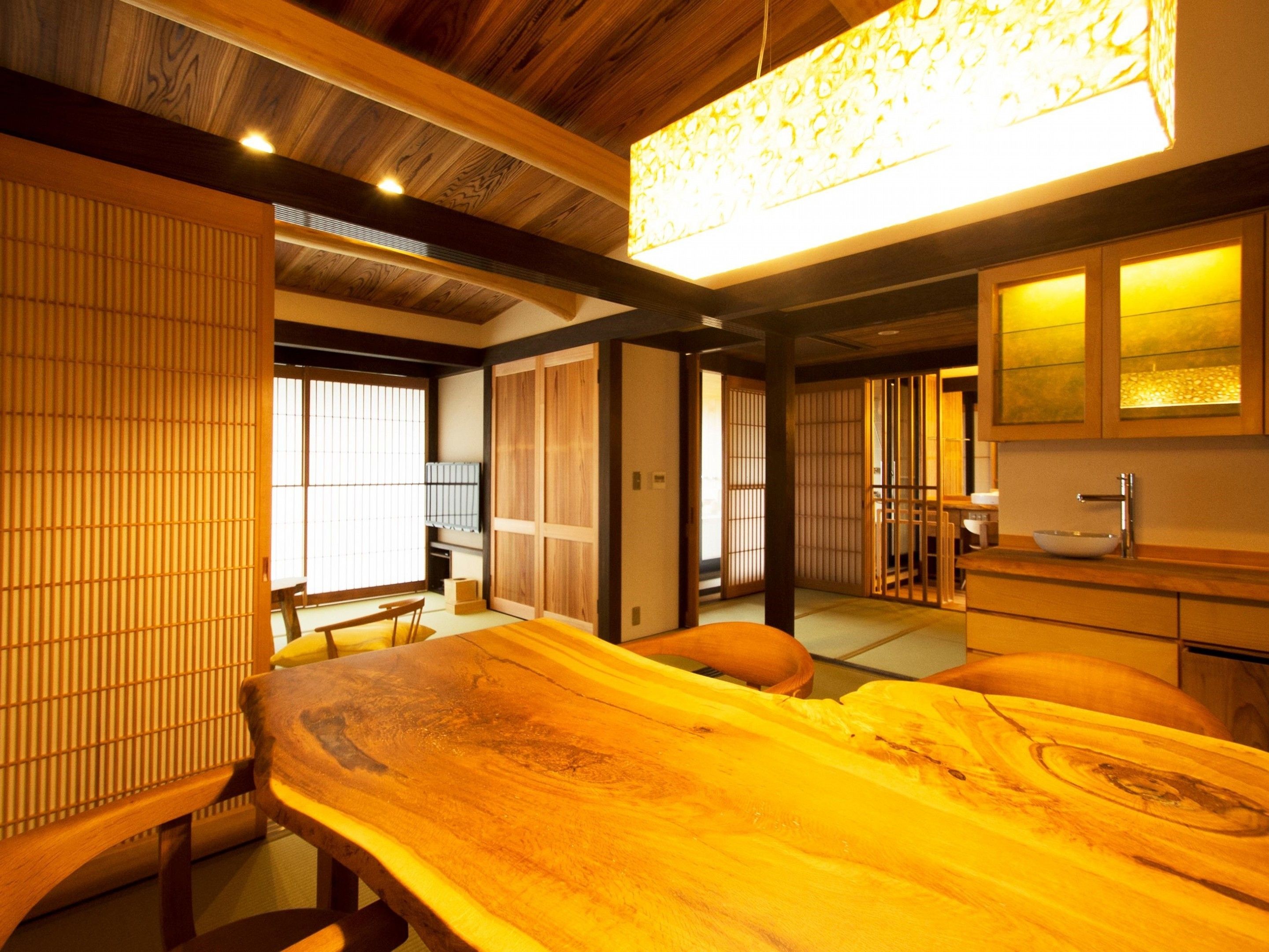 Um quarto em estilo japonês tradicional, com tatames, portas deslizantes e uma mesa de madeira.