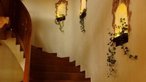 Uma escadaria de madeira com castiçais elaborados e plantas trepadeiras.