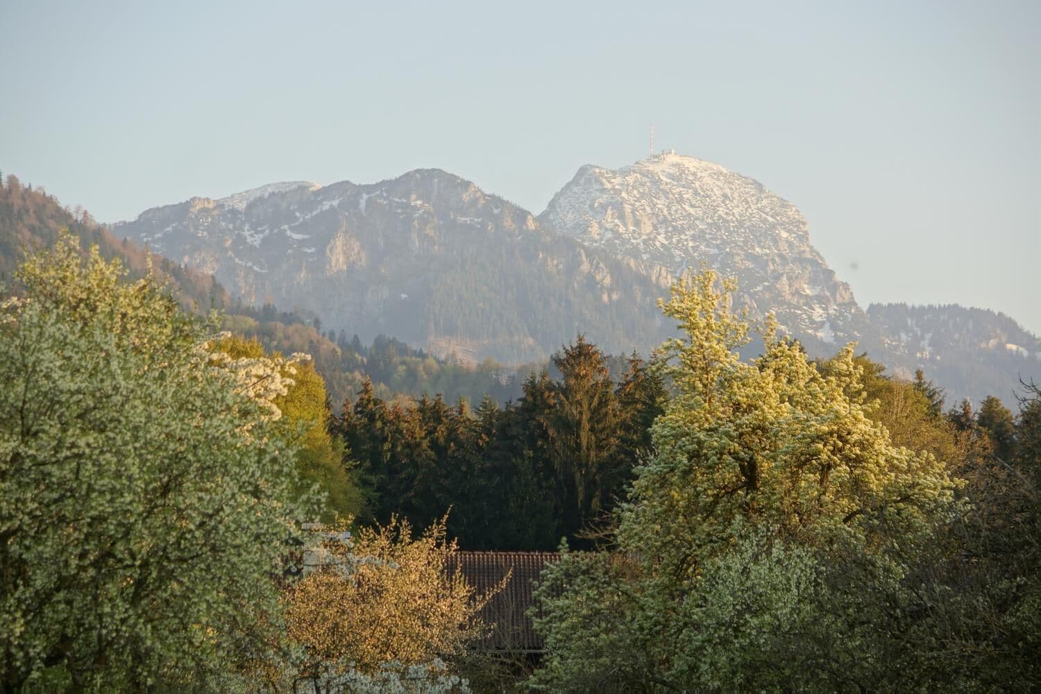Paisagem montanhosa com uma cabana em primeiro plano.