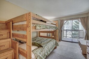 Quarto com beliche e porta de vidro deslizante para uma varanda.