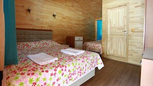 Um quarto com painéis de madeira, uma cama, uma mesa de cabeceira e um guarda-roupa.