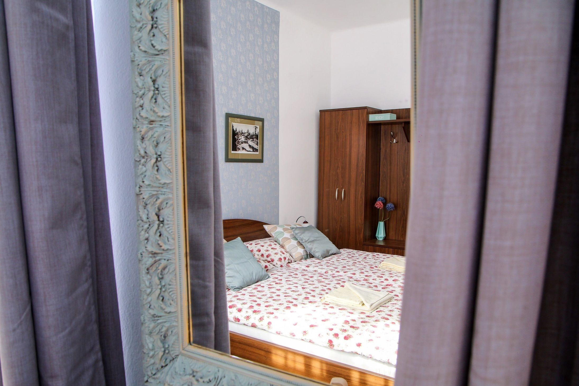 Quarto com uma cama, um guarda-roupa e um quadro na parede.