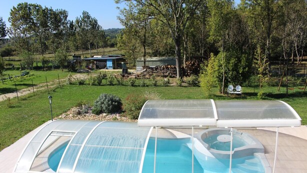 Piscina com estrutura de vidro e banheira de hidromassagem.