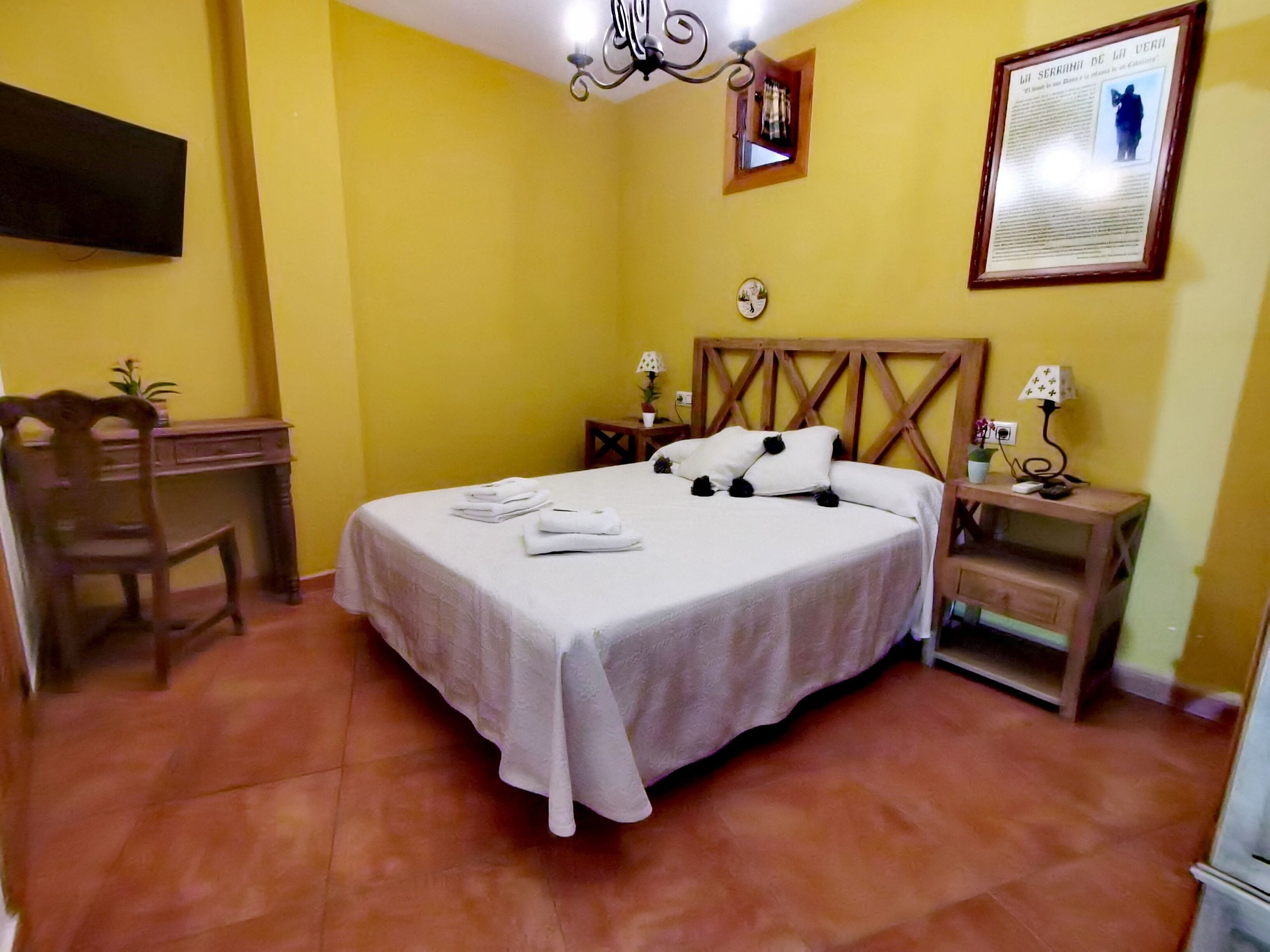 Um quarto bem arrumado, com cama, escrivaninha e cadeira.