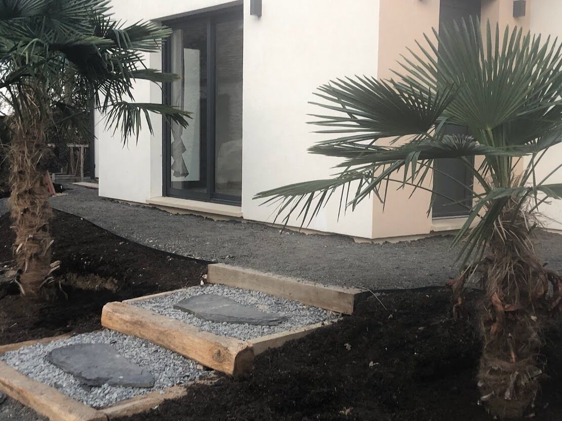 Um edifício moderno com fachada branca, porta de vidro e um caminho de concreto que leva à entrada.