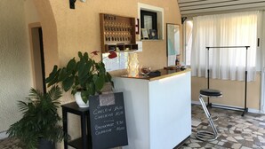 Um café com um quadro negro de cardápio, uma planta e um balcão.