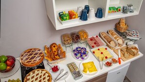 Mesa de buffet com diversos alimentos, incluindo tortas, doces e patês.