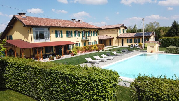 Um hotel com piscina, área de estar externa e um jardim bem cuidado.