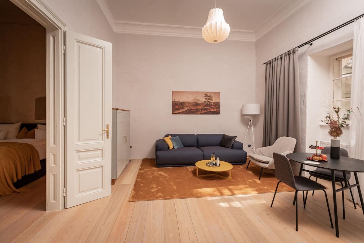Uma sala de estar moderna com sofá, mesa de centro e área de jantar.