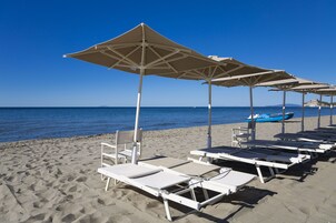 Praia particular, espreguiçadeiras, guarda-sóis