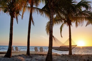 Na praia, espreguiçadeiras, guarda-sóis de praia, toalhas de praia 