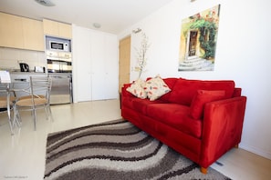 Apartamento standard, 1 quarto | Área de estar | TV de tela plana 32 polegadas com canais a cabo, TV