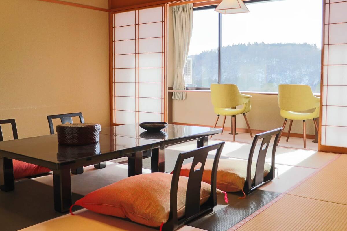 Um quarto japonês tradicional com tatames, uma mesa baixa e painéis shoji.