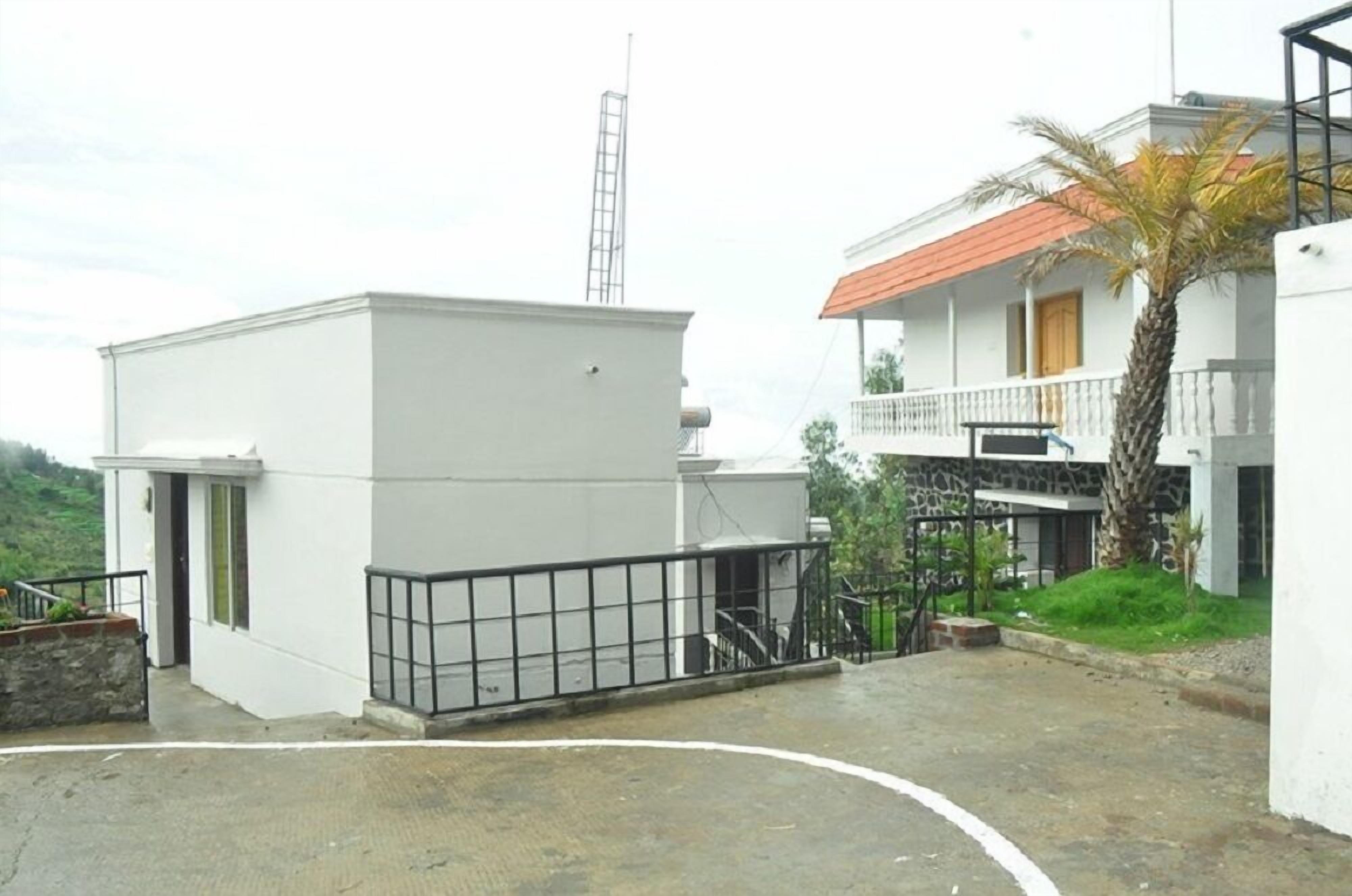 Um edifício moderno com fachada branca, varanda e telhado vermelho.