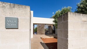 Uma villa chamada "Villa Sofia" com entrada em concreto, um caminho pavimentado e uma pequena área de jardim.