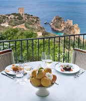 Mesa posta para dois com vista para o mar e falésias.