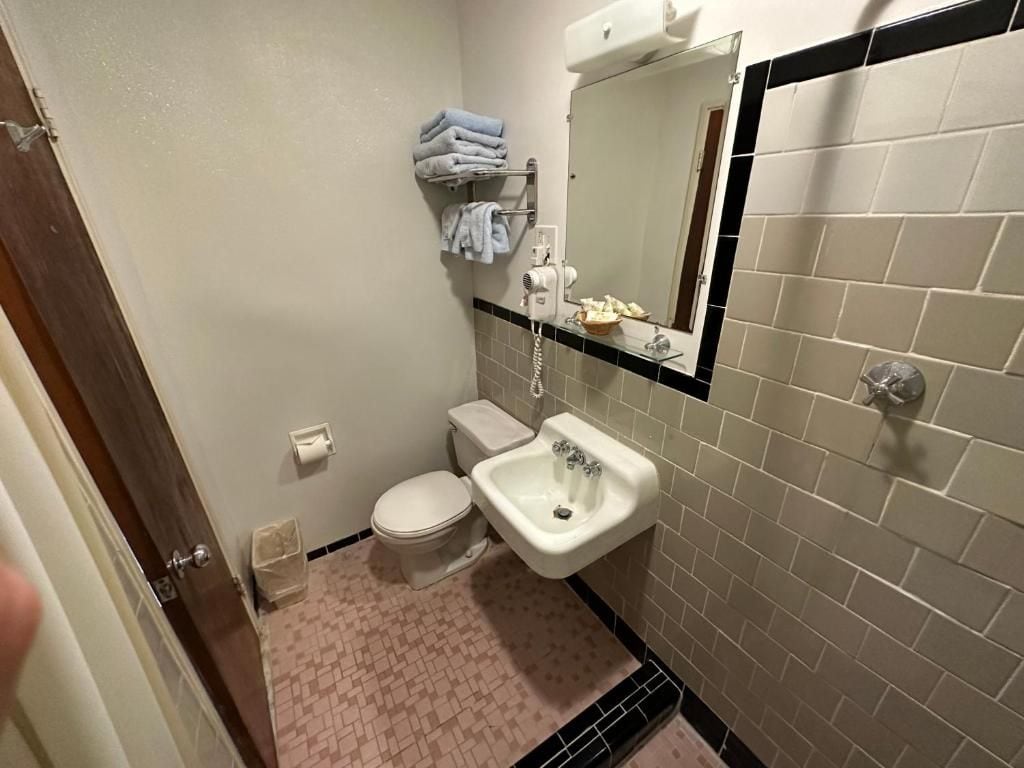 Casa de banho pequena com sanita, lavatório e porta-toalhas.